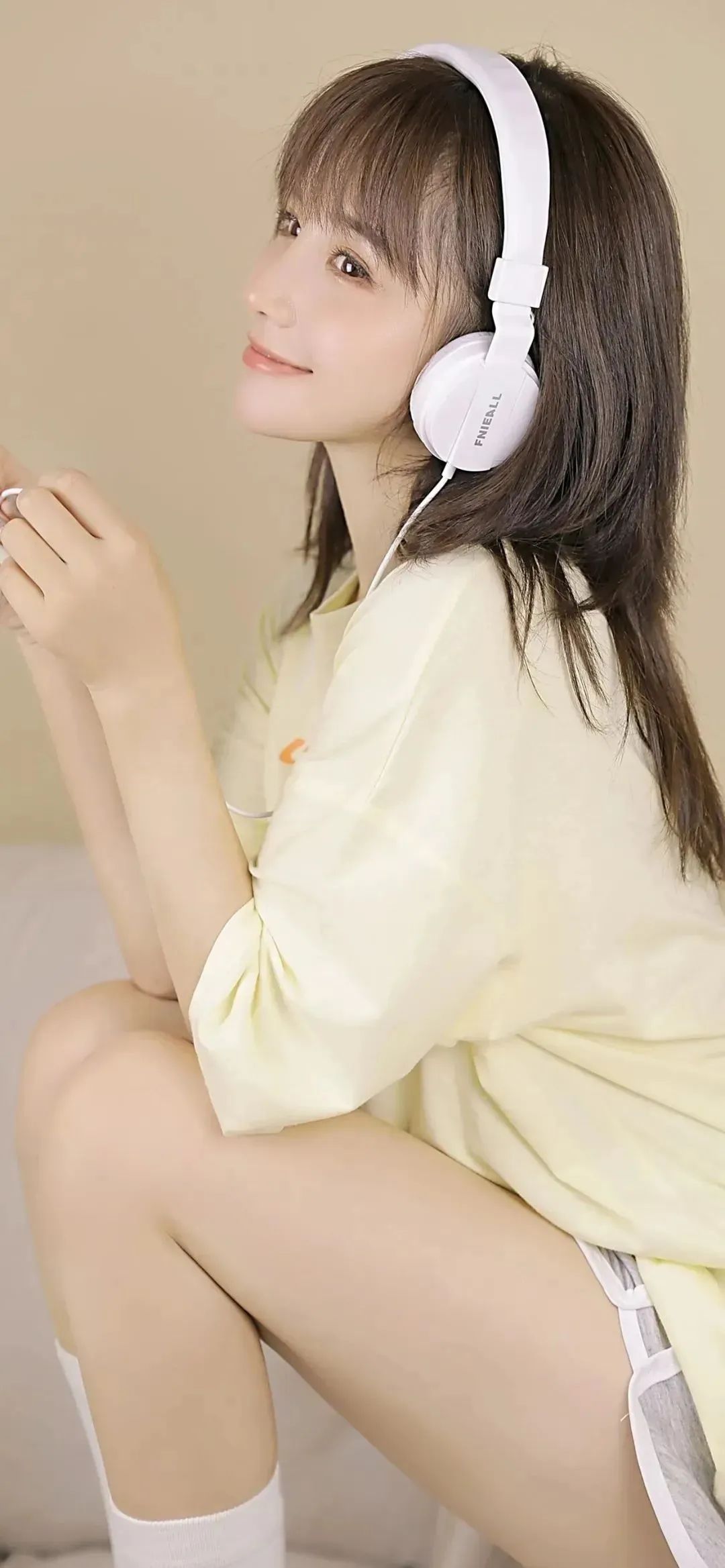 头戴白色耳机的女孩，身穿淡黄上衣，尽显清新可爱 YYDS！爆赞手机壁纸！表情包图片gif动图 - 求表情网,斗图从此不求人!